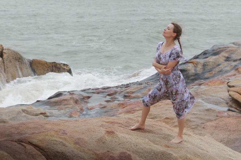 The Girl is Sitting on a Large Rock, on Which the Waves are Breaking ...