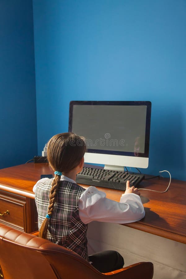 Girl is Sitting at the Table and Working and Studying at the Computer ...