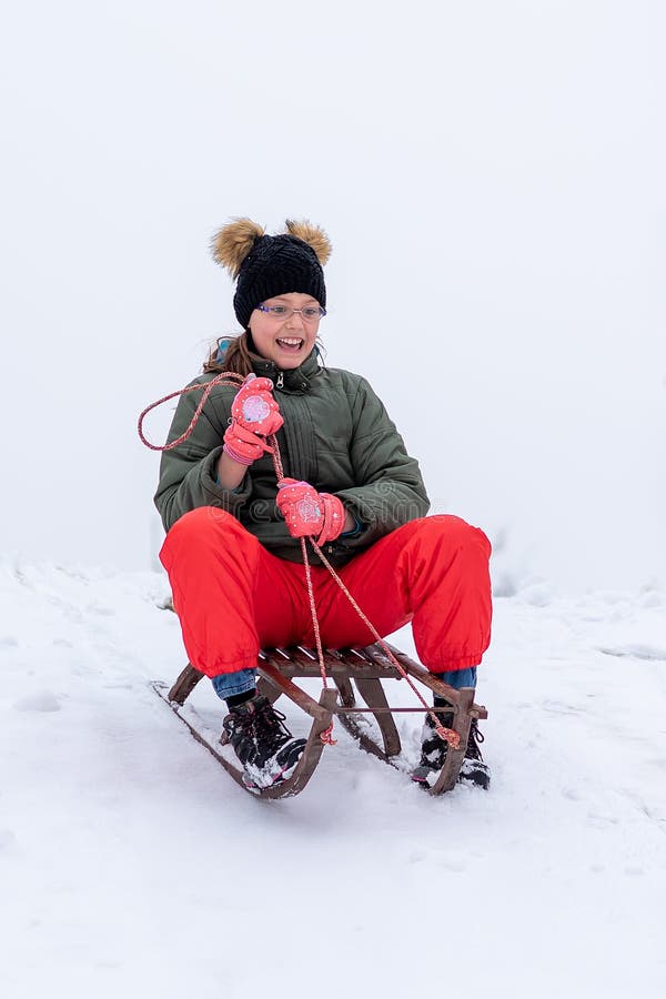 Girl on a Sled Playing in the Snow. Stock Photo - Image of care ...