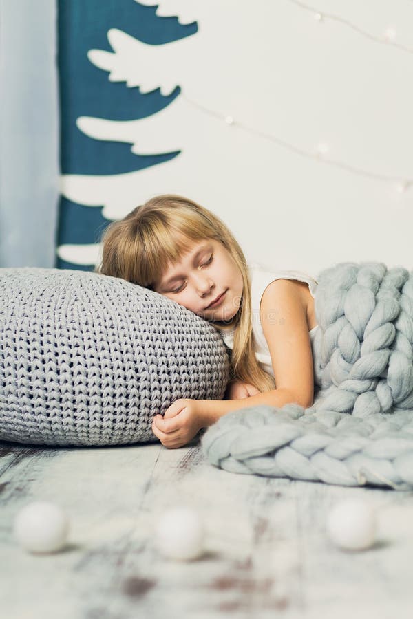 The Girl is Sleeping on a Pillow Under a Rug on the Background of a ...