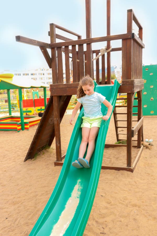 Girl Slides Down a Slide on the Playground Stock Photo - Image of cute ...