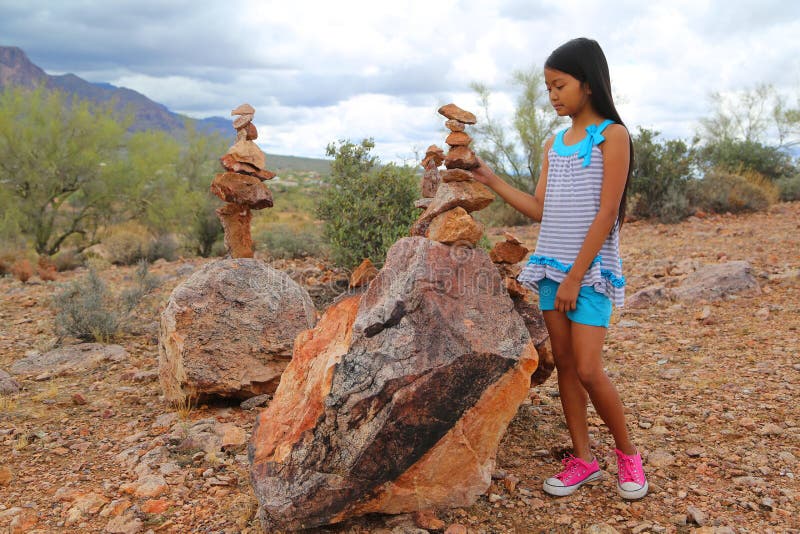 Girl stacking rocks stock image. Image of danger, girl - 54227837