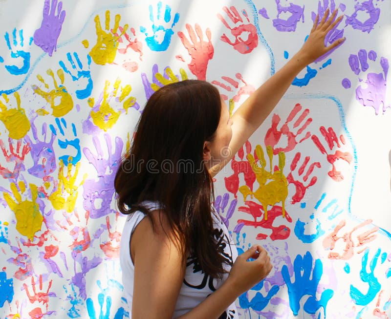 Girl Stamps Trace Hands on Wall with Prints Stock Photo - Image of ...