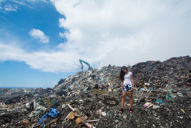 Girl Standing and Looking Sadly Down among Trash at Garbage Dump Stock ...