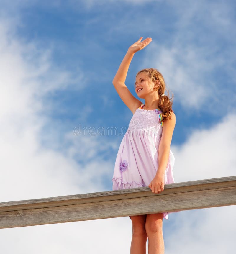 Girl Standing on a Railing with a Hand Raised Stock Photo - Image of ...