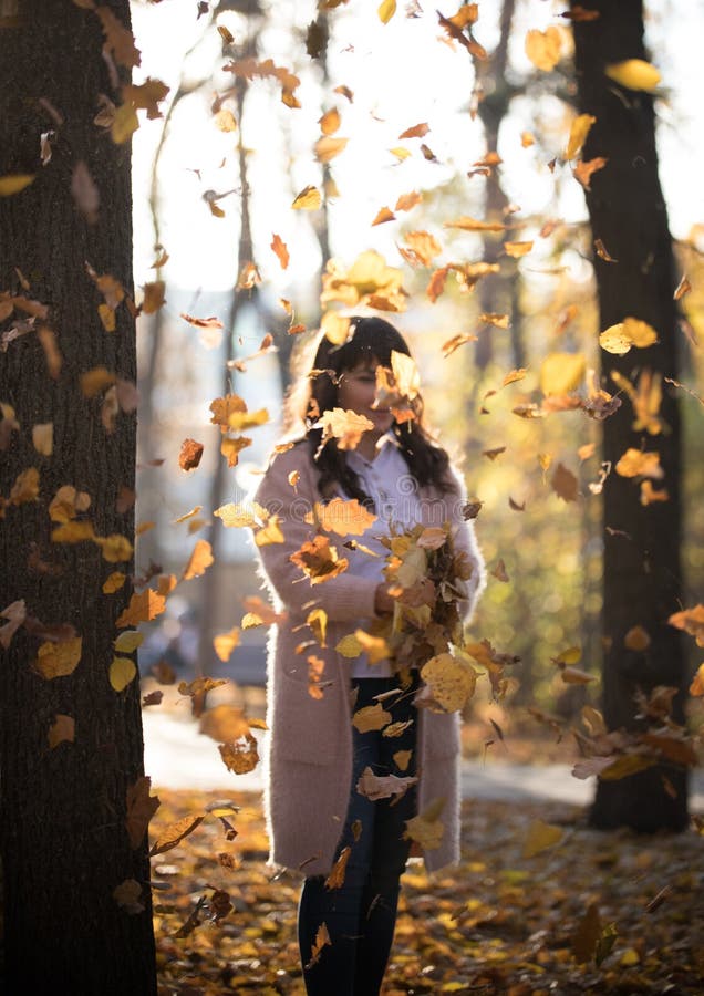 The Girl Stands Under the Autumn Falling Leaves in the Park Stock Photo ...