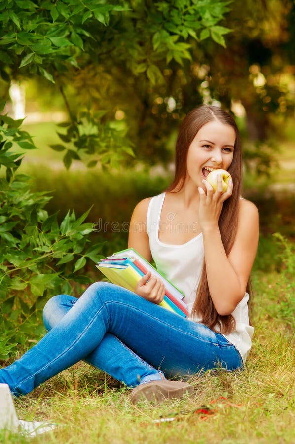 Girl Student with Books Eating an Apple Stock Photo - Image of ...