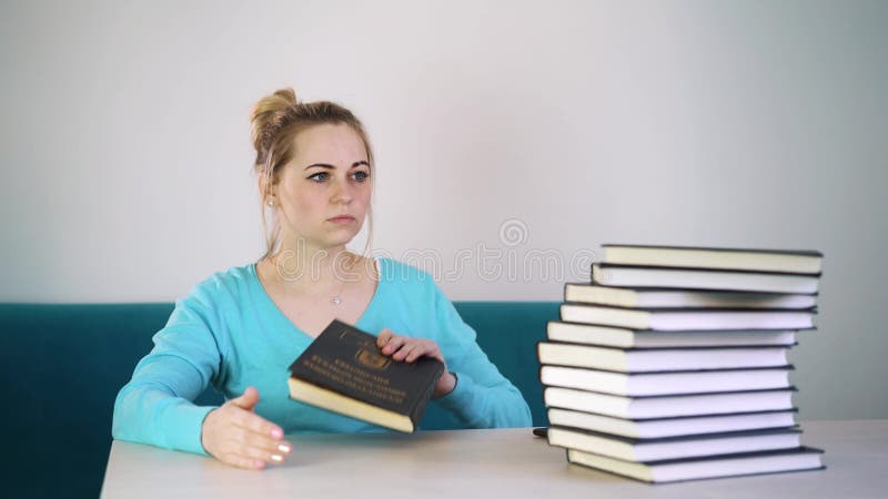 Girl Student Chooses a Phone, Pushing a Stack of Books on the Table ...