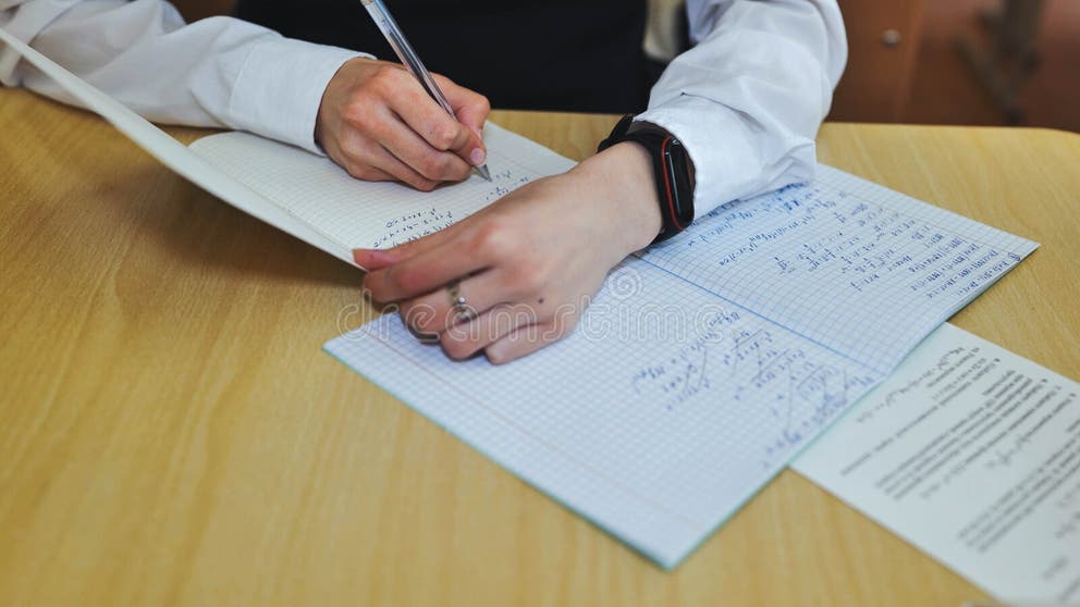 A Girl Student Writes Math Formulas in a Notebook. Notebook Close-up ...
