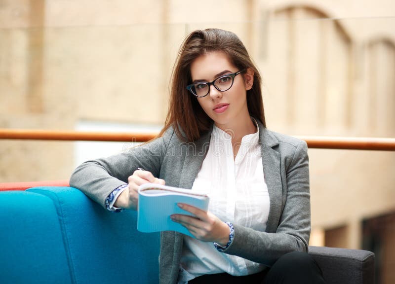 Girl Student Writing in Notebook Looking at Camera Stock Image - Image ...