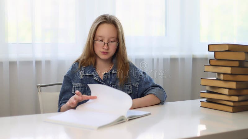 The Girl is Studying Lessons at a White Table with Books. Stock Footage ...