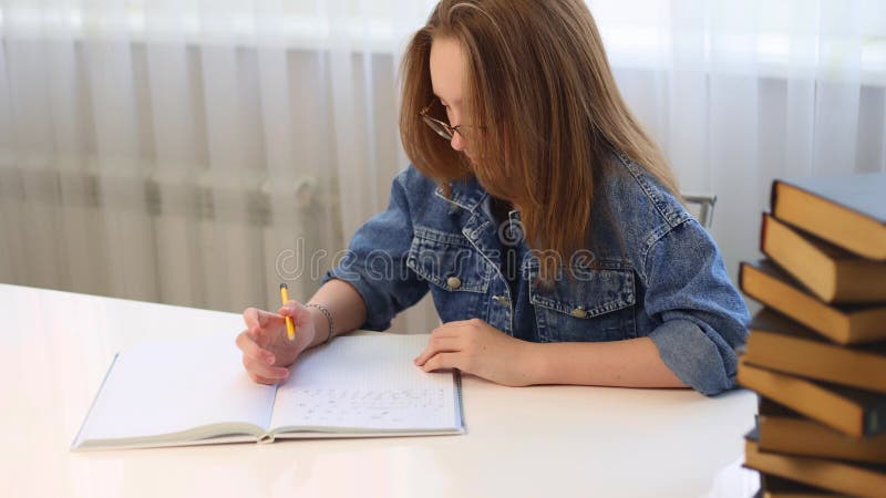 The Girl is Studying Lessons at a White Table with Books. Stock Footage ...