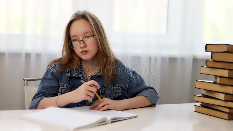 The Girl is Studying Lessons at a White Table with Books. Stock Footage ...