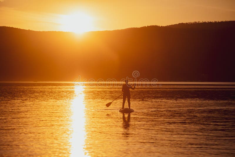 Girl on Sup Board with Beautiful Colored Sunrise Background Mountains ...