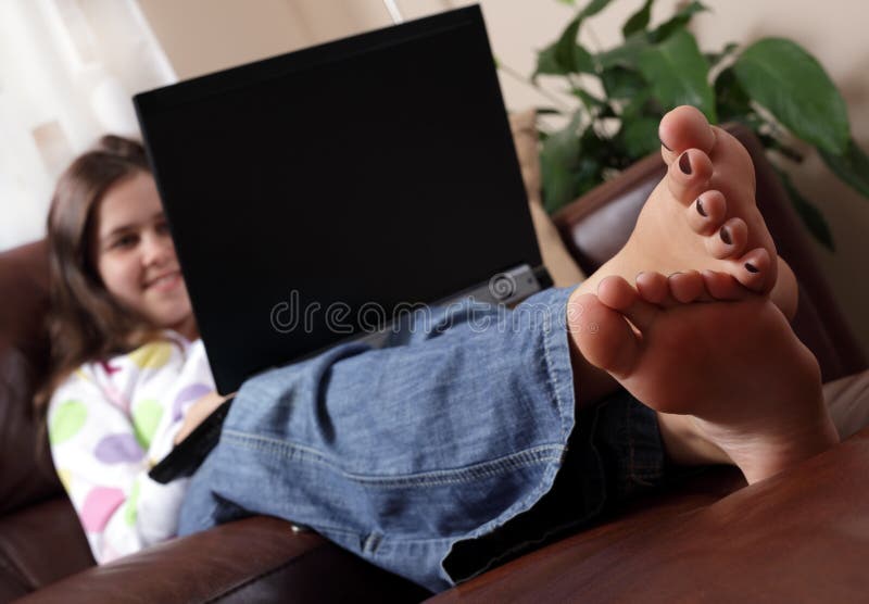 Girl Surfing the Internet with Feet Up Stock Photo - Image of jeans ...