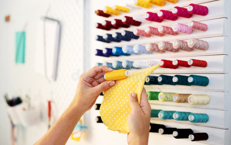 A Girl Tailor Selects Threads for Colored Fabric. Close-up of Hands ...