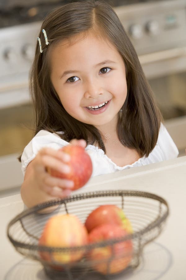 Girl Taking Apple from Fruit Basket at Home Stock Photo - Image of head ...