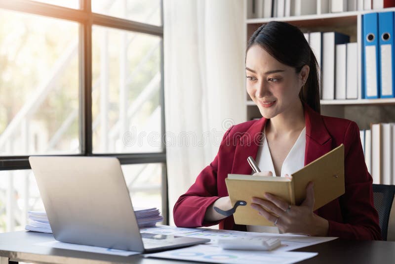 Girl Taking Note Book Eye on Laptop There is Graph Data on the Table ...