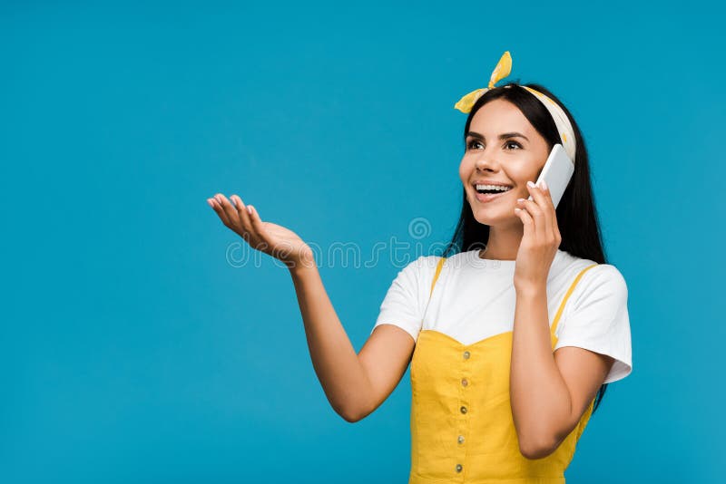Girl Talking on Smartphone and Gesturing Isolated on Blue Stock Photo ...