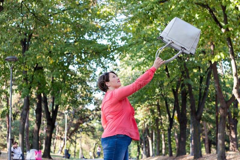 Girl Throwing Her Bag in the Air in a Park Stock Image - Image of pose ...
