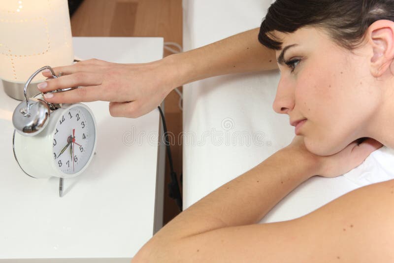 Girl turning off her clock stock photo. Image of time - 22184374