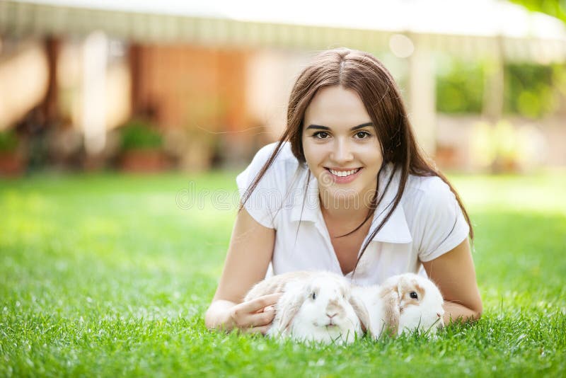 Girl with Two Pet Rabbit in a Park Stock Photo - Image of lying, care ...