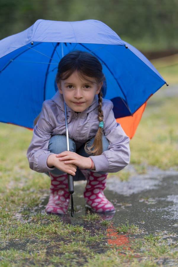 Girl with an Umbrella in the Rain Playing Stock Photo - Image of autumn ...