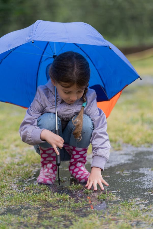 Girl with an Umbrella in the Rain Playing Stock Image - Image of boot ...