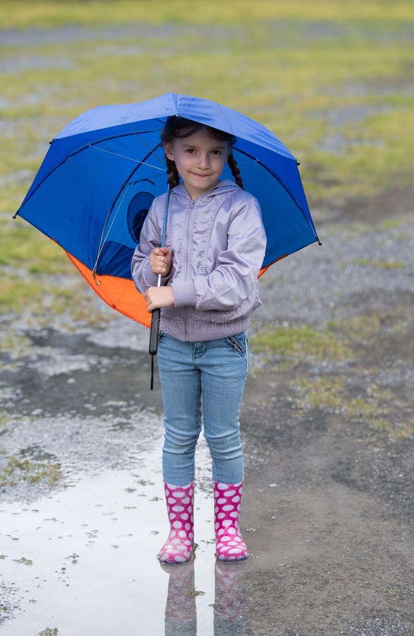 Girl with an Umbrella in the Rain Playing Stock Photo - Image of autumn ...