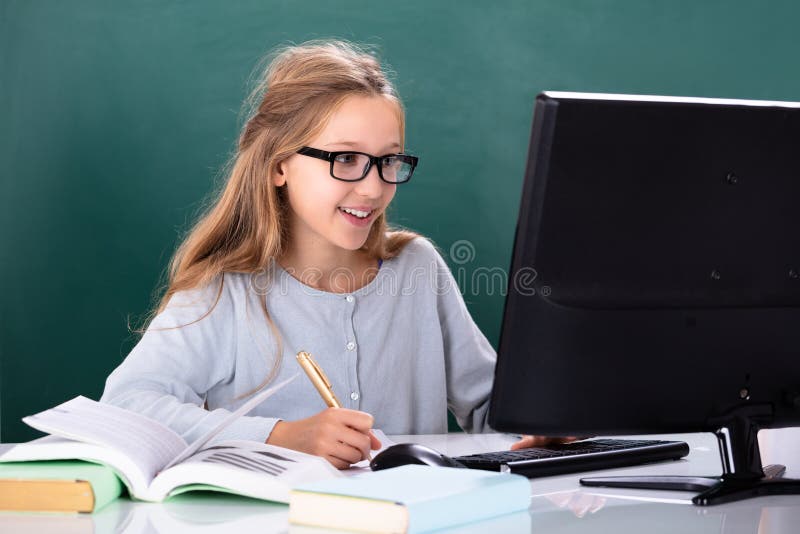 Girl Using Computer in Classroom Stock Photo - Image of innocence ...