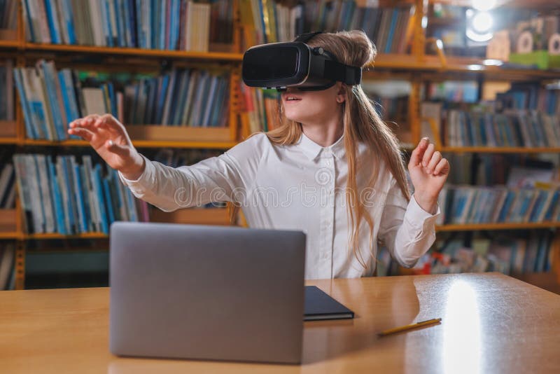 Girl Using Devices in the Library, a Laptop and VR Headset Stock Photo ...