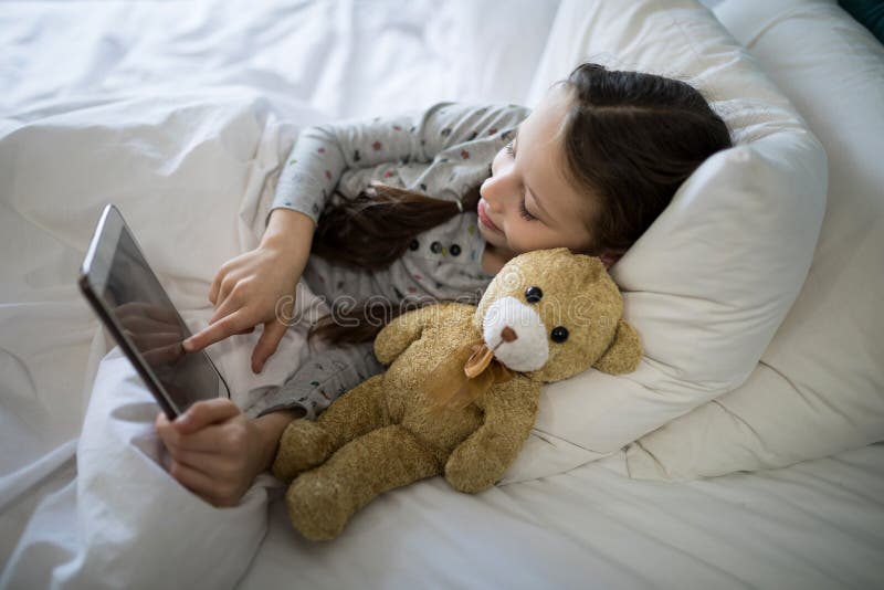 Girl Using Digital Tablet while Lying on Bed Stock Image - Image of ...