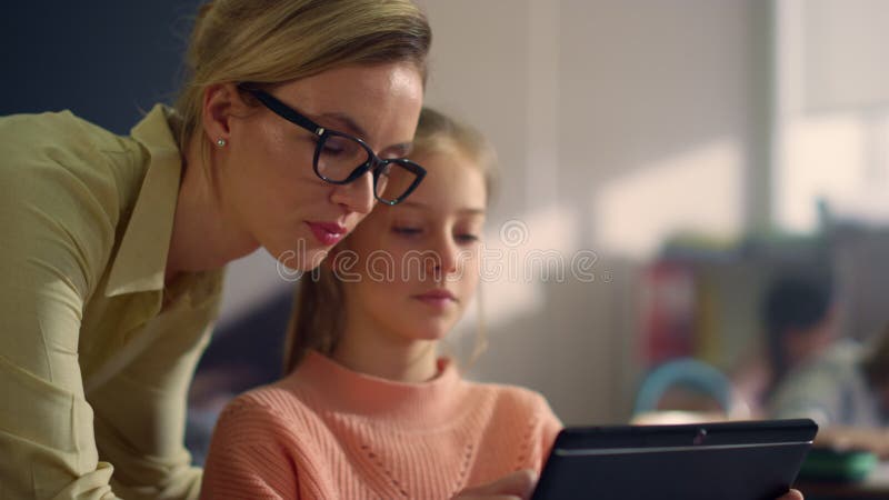 Girl Using Digital Tablet. Teacher Helping Student To Do Class Work on ...