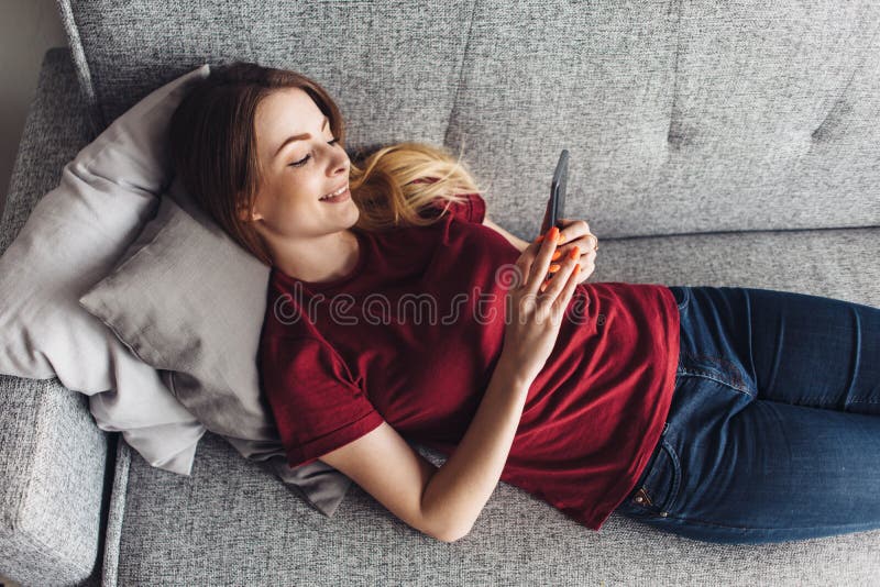 Girl Using Phone while Lying on Sofa at Home Stock Image - Image of ...