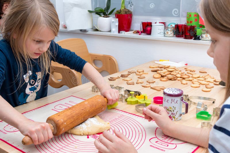 A Girl is Using the Rolling Pin To Roll Out the Dough on the Tab Stock ...
