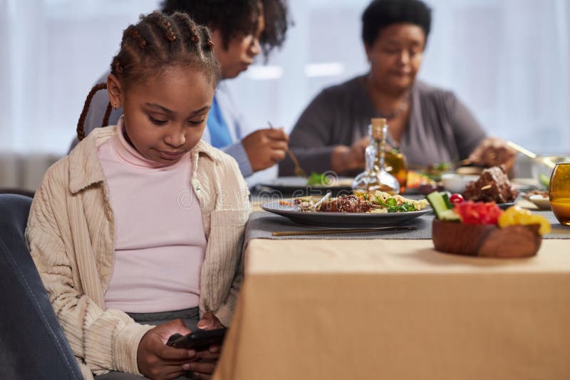 Girl Using Smartphone Under Table at Dinner Stock Image - Image of ...