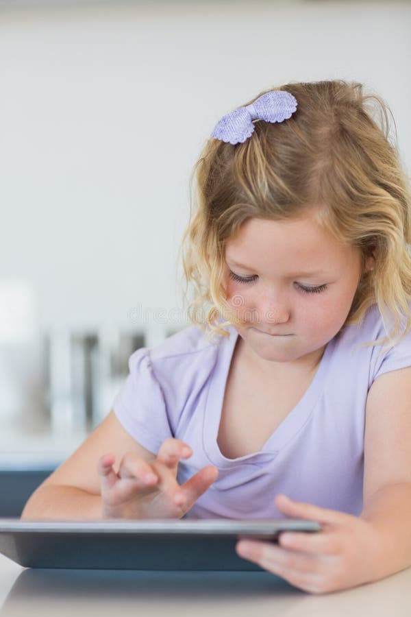 Girl Using Tablet Computer at Table Stock Photo - Image of house ...