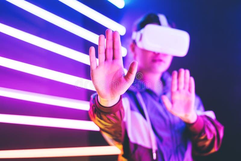 Girl Using VR Goggles in Colorful Neon Lights Studio. Put Palm Forward ...