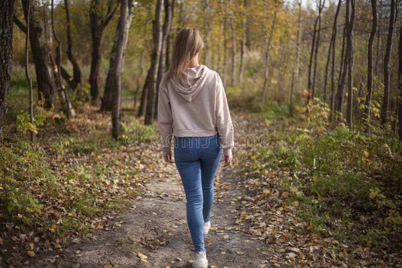 The Girl Walks Through The Autumn Forest A Walk In The Park In Warm