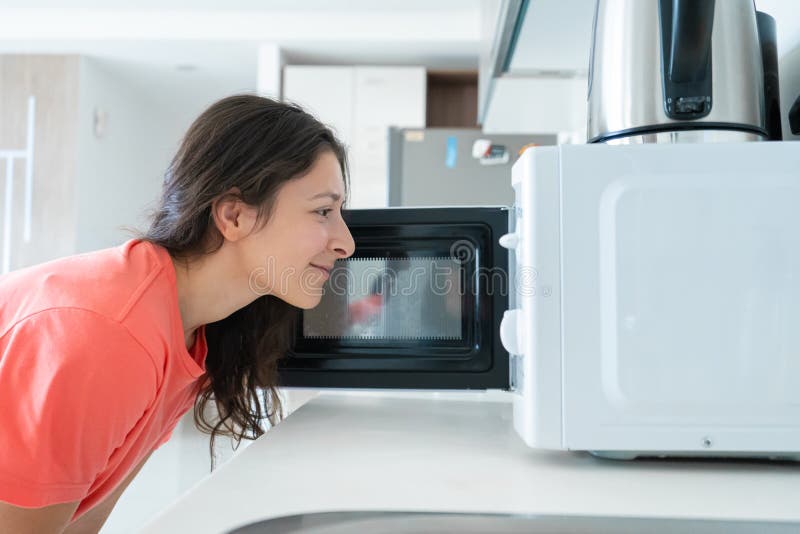 The Girl Warms Food in the Microwave. a Quick Snack Stock Photo - Image ...