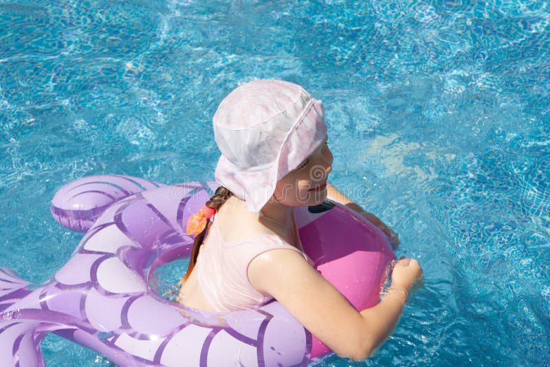 A Girl with an Inflatable Circle and a Boy Play in the Pool. Stock ...