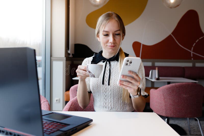A Girl Works at a Computer in a Coffee Shop. Stock Photo - Image of ...