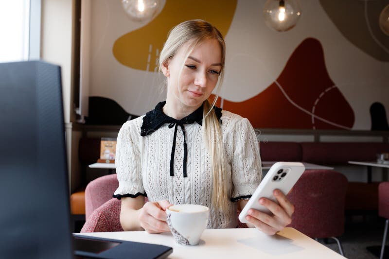 A Girl Works at a Computer in a Coffee Shop. Stock Photo - Image of ...