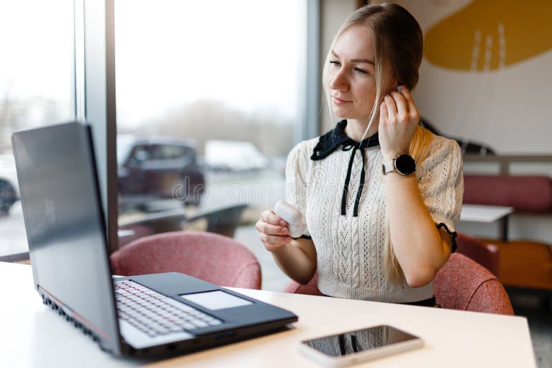 A Girl Works at a Computer in a Coffee Shop. Stock Photo - Image of ...