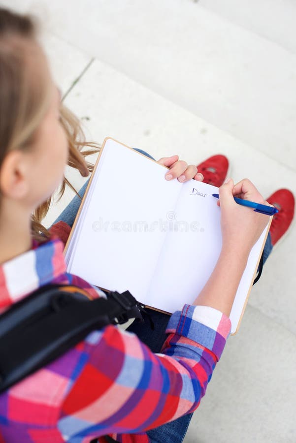 Girl writing in her diary stock photo. Image of sitting - 62007858