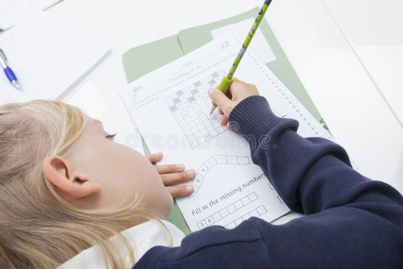 Girl Writing Numbers on Paper at Table Stock Photo - Image of leaning ...