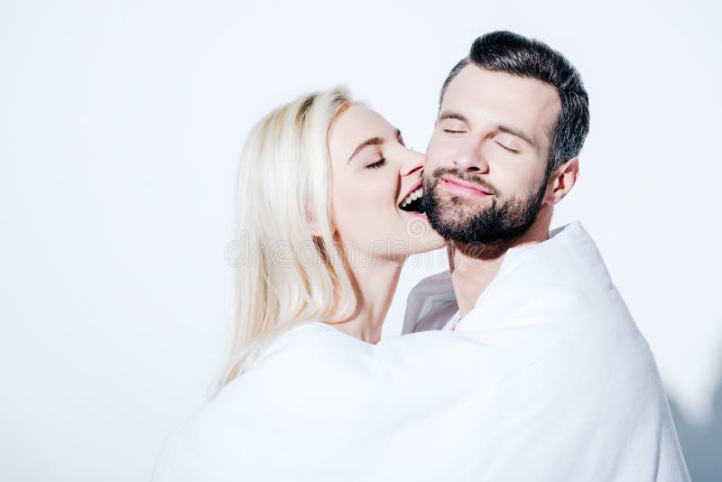 Girlfriend Biting Cheek of Boyfriend Covered in Blanket Stock Image ...