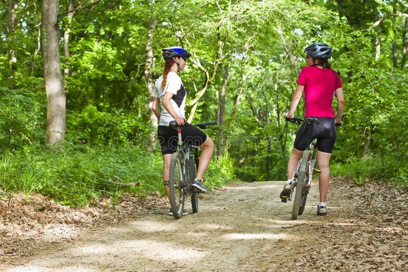 Girls biking in the forest stock photo. Image of forest - 31882716