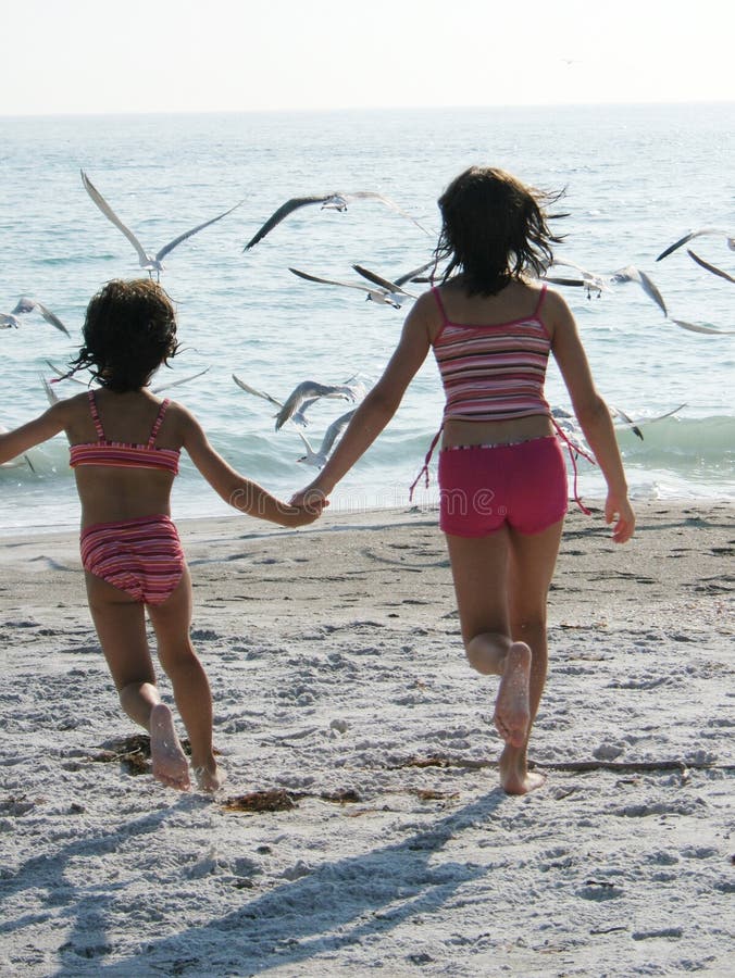 Girls Chasing Birds on the Beach Stock Image - Image of play, birds ...