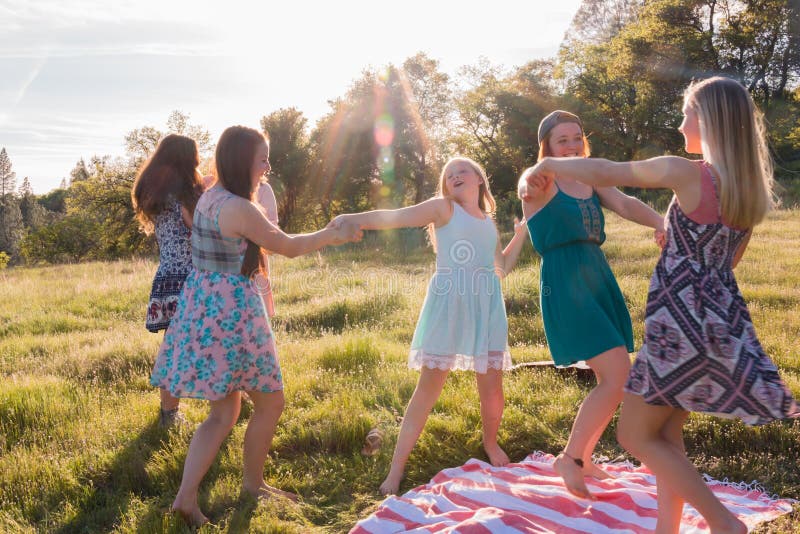 Girls Dancing in Grassy Field with Sunlight Overhead Stock Image ...